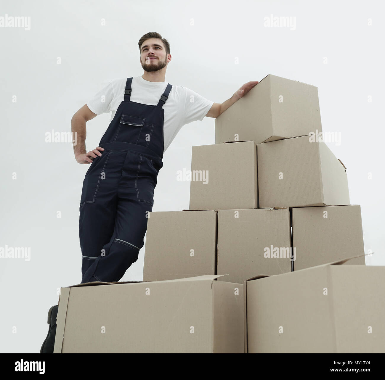 Young men carrying a box to the pile of boxes Stock Photo - Alamy