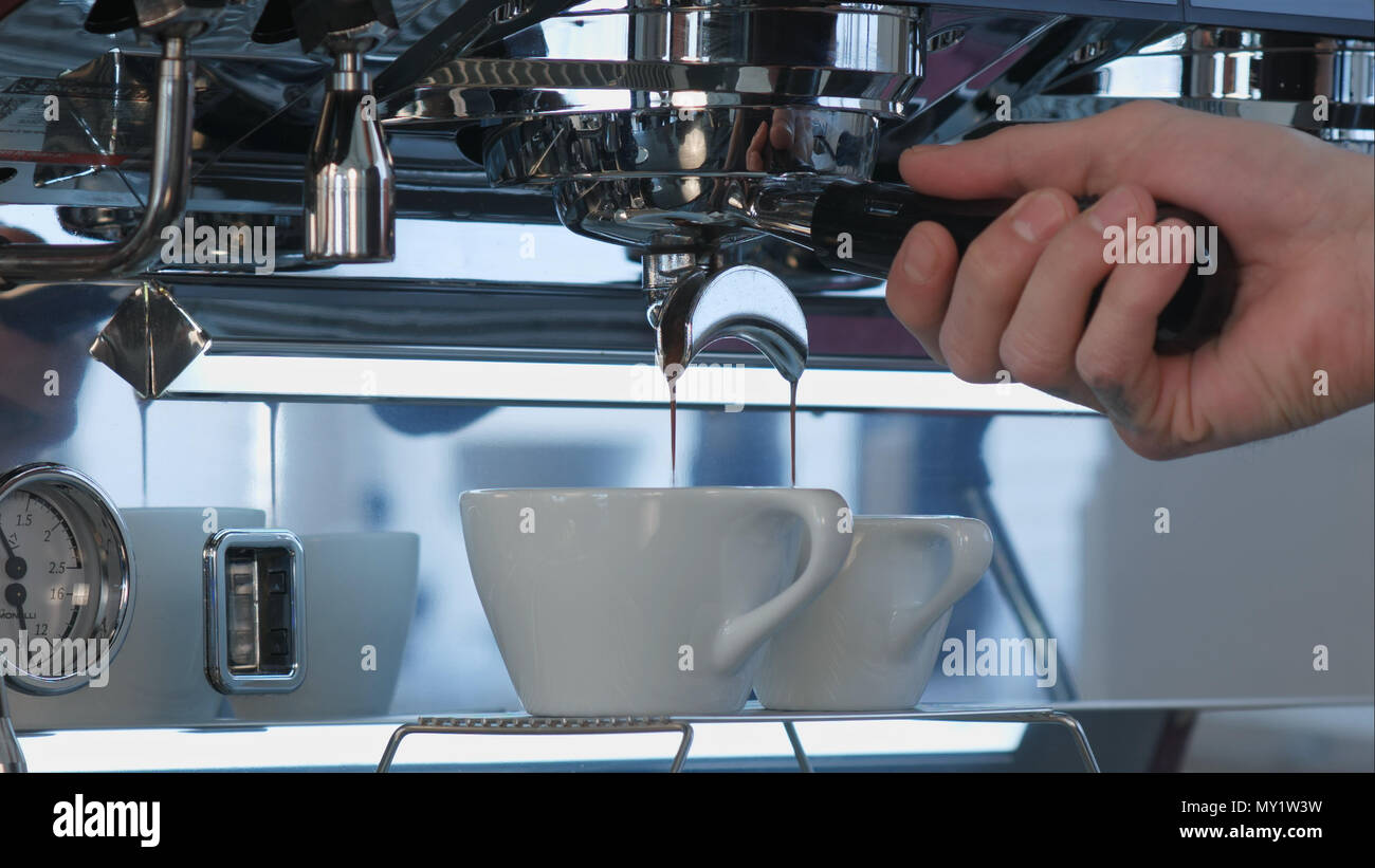 Espresso coffee pouring from espresso machine Stock Photo - Alamy