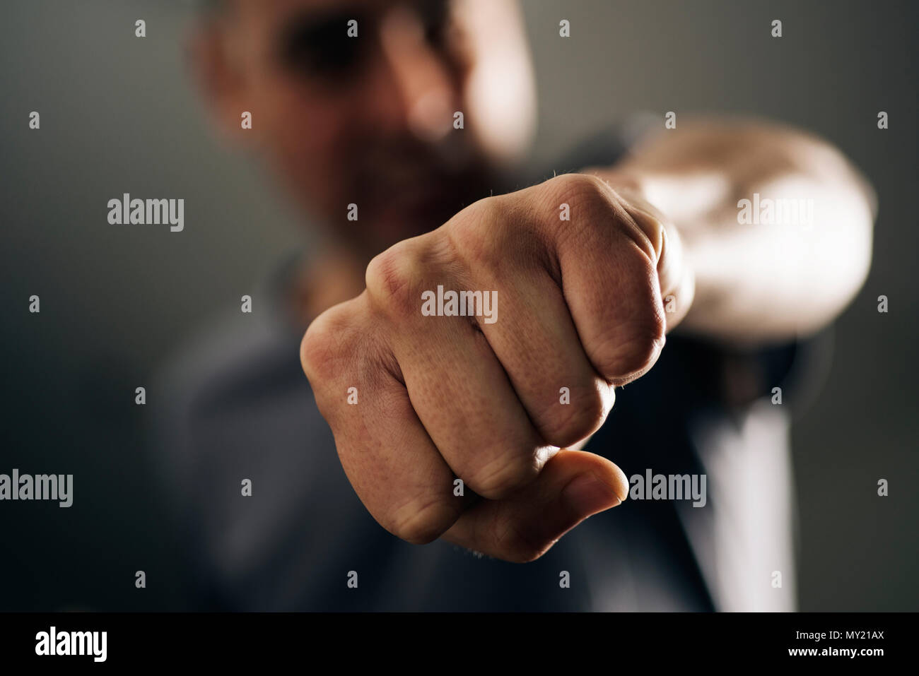 closeup of a young caucasian man throwing a punch to the observer, with ...