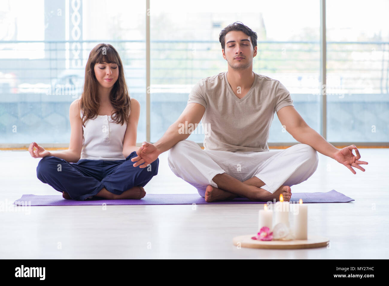 Personal coach helping during yoga session Stock Photo - Alamy
