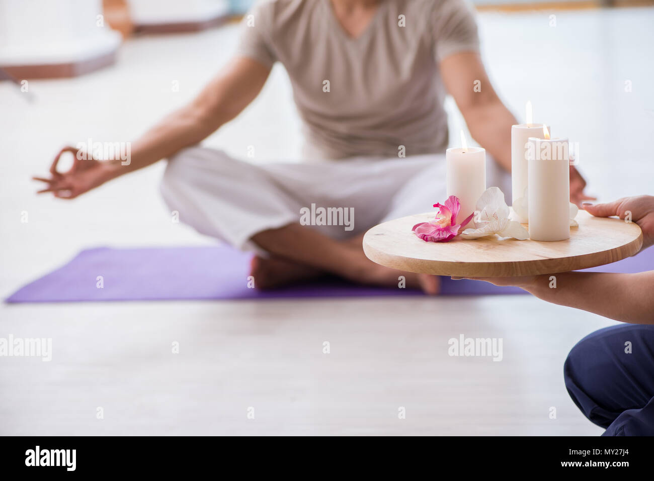 Personal coach helping during yoga session Stock Photo - Alamy