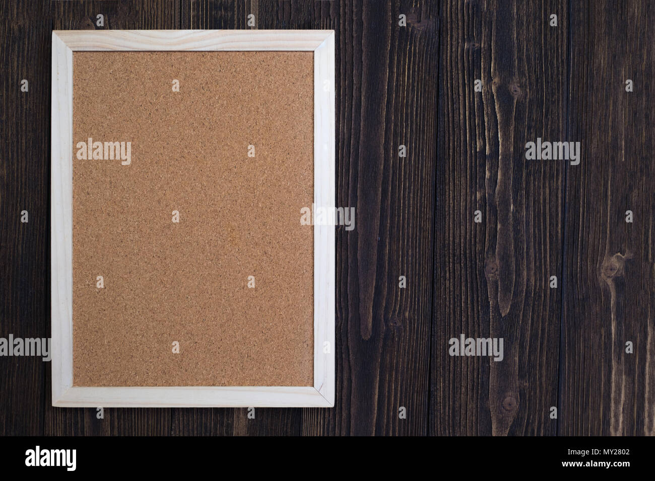 Empty cork board with wooden frame on wooden desk, top view with copy ...