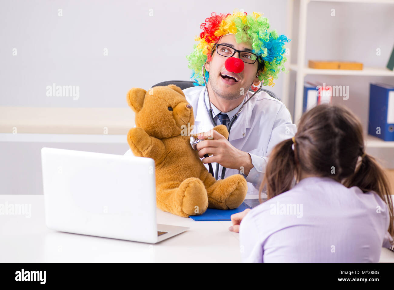 Funny pediatrician with little girl at regular check-up Stock Photo - Alamy