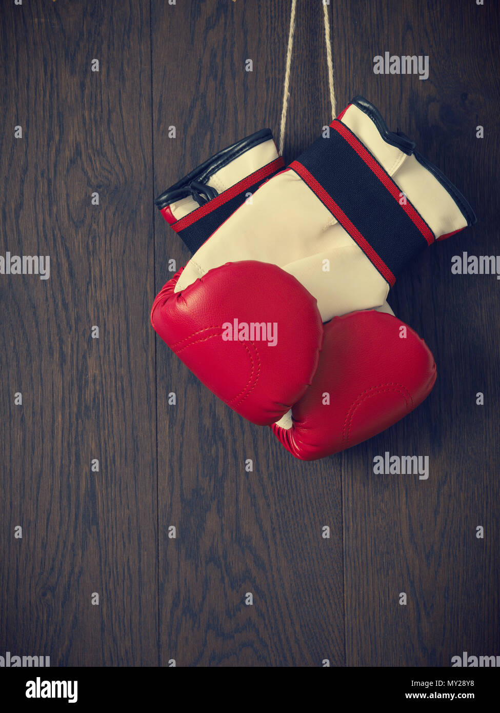 Red boxing gloves on a rustic wooden wall, sports or assertiveness ...