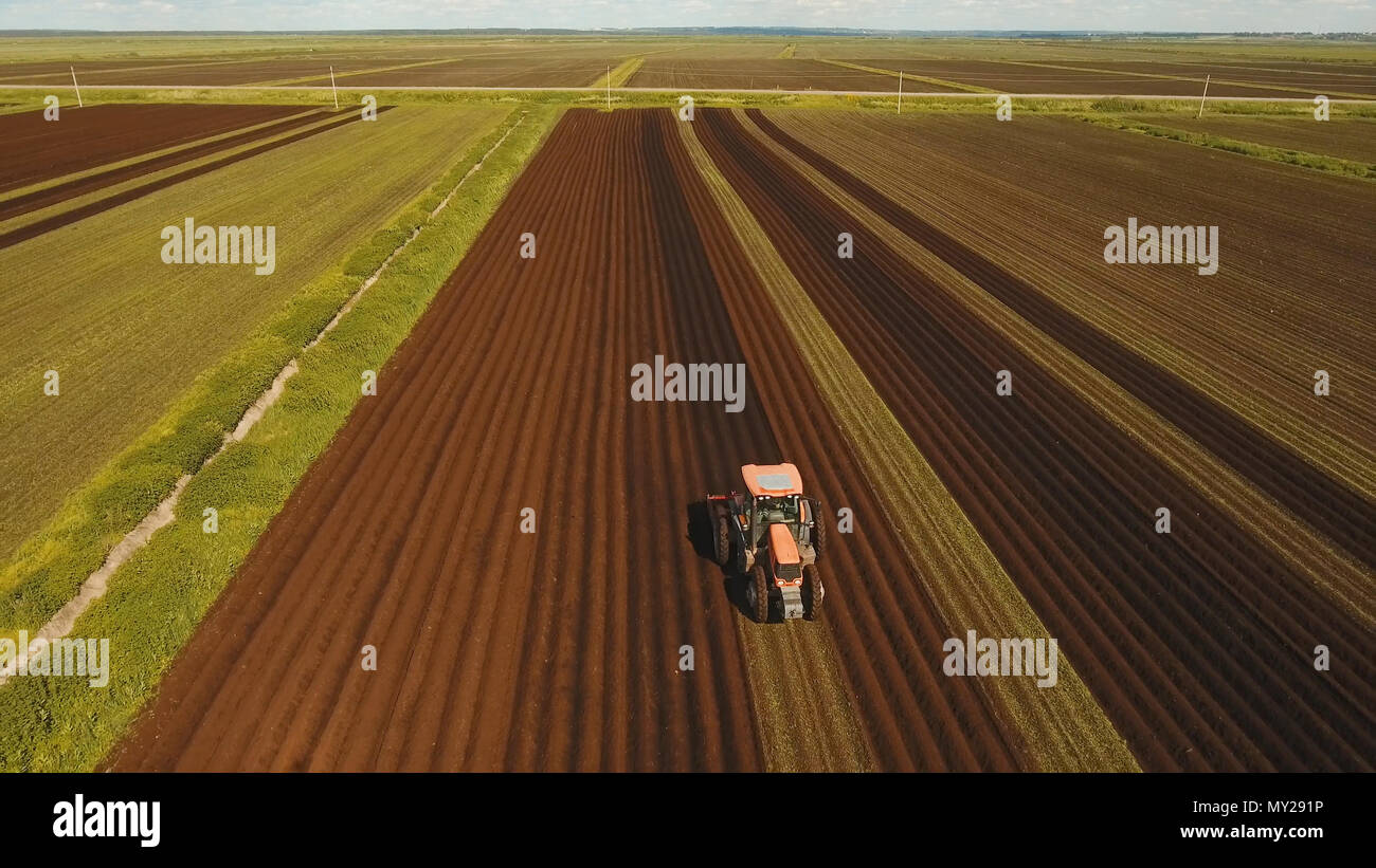 Farmer in tractor preparing land with seedbed cultivator in farmlands ...