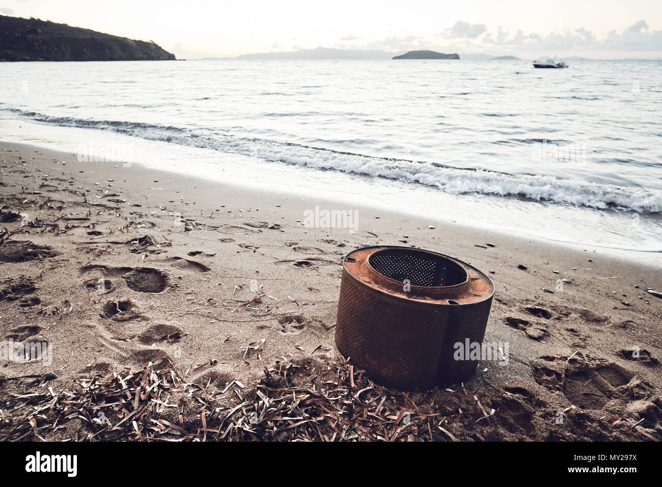 Rusty washing machine tub on the beach illustrating the pollution of ...