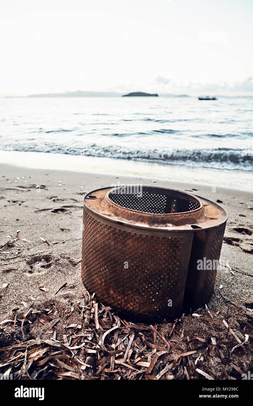Rusty washing machine tub on the beach illustrating the pollution of ...