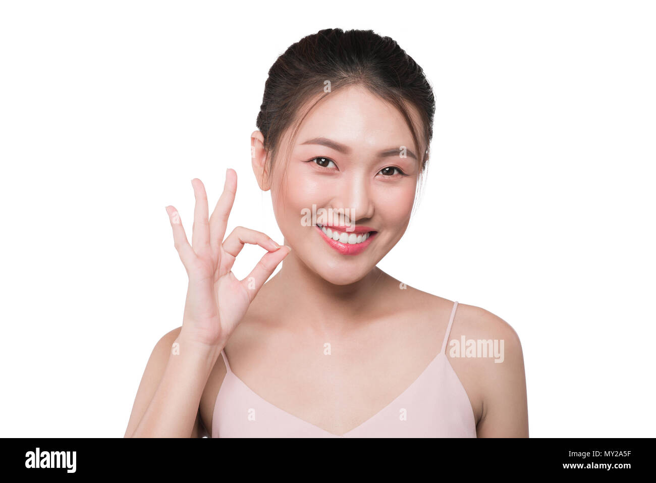 Happy young woman showing ok sign with fingers an winking isolated on ...