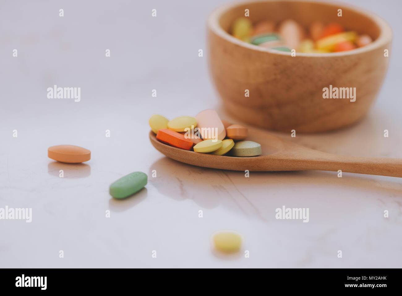 Assorted pharmaceutical medicine pills, tablets and capsules on wooden ...