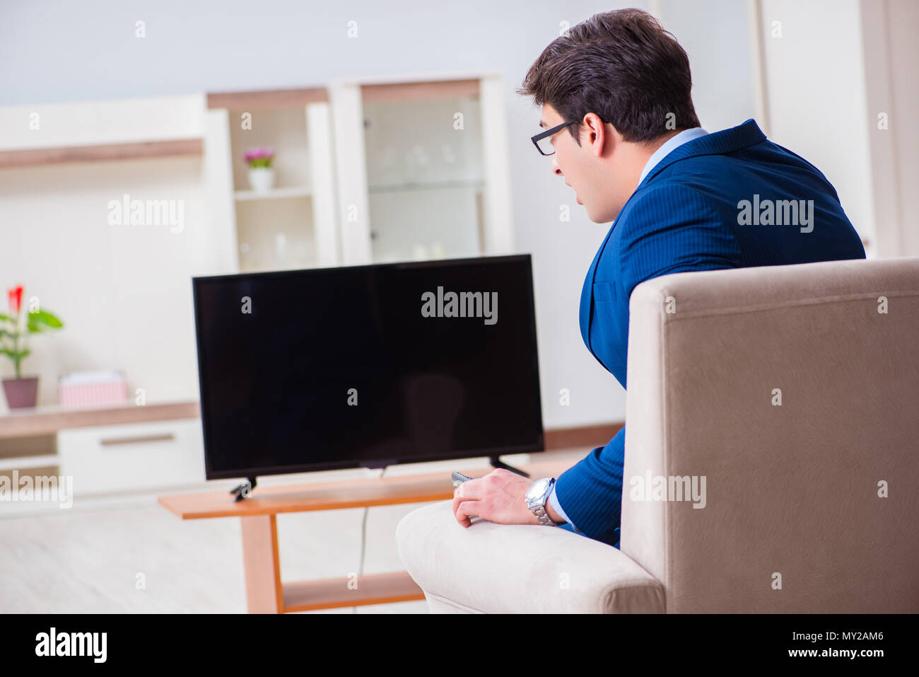 Businesman watching tv in office Stock Photo - Alamy