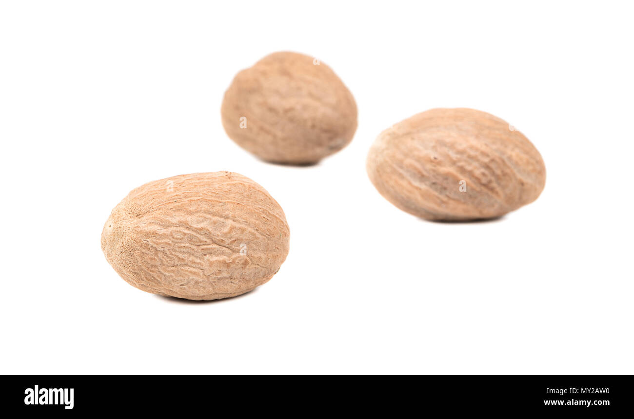 Three scattered dry nutmeg isolated on white background Stock Photo - Alamy