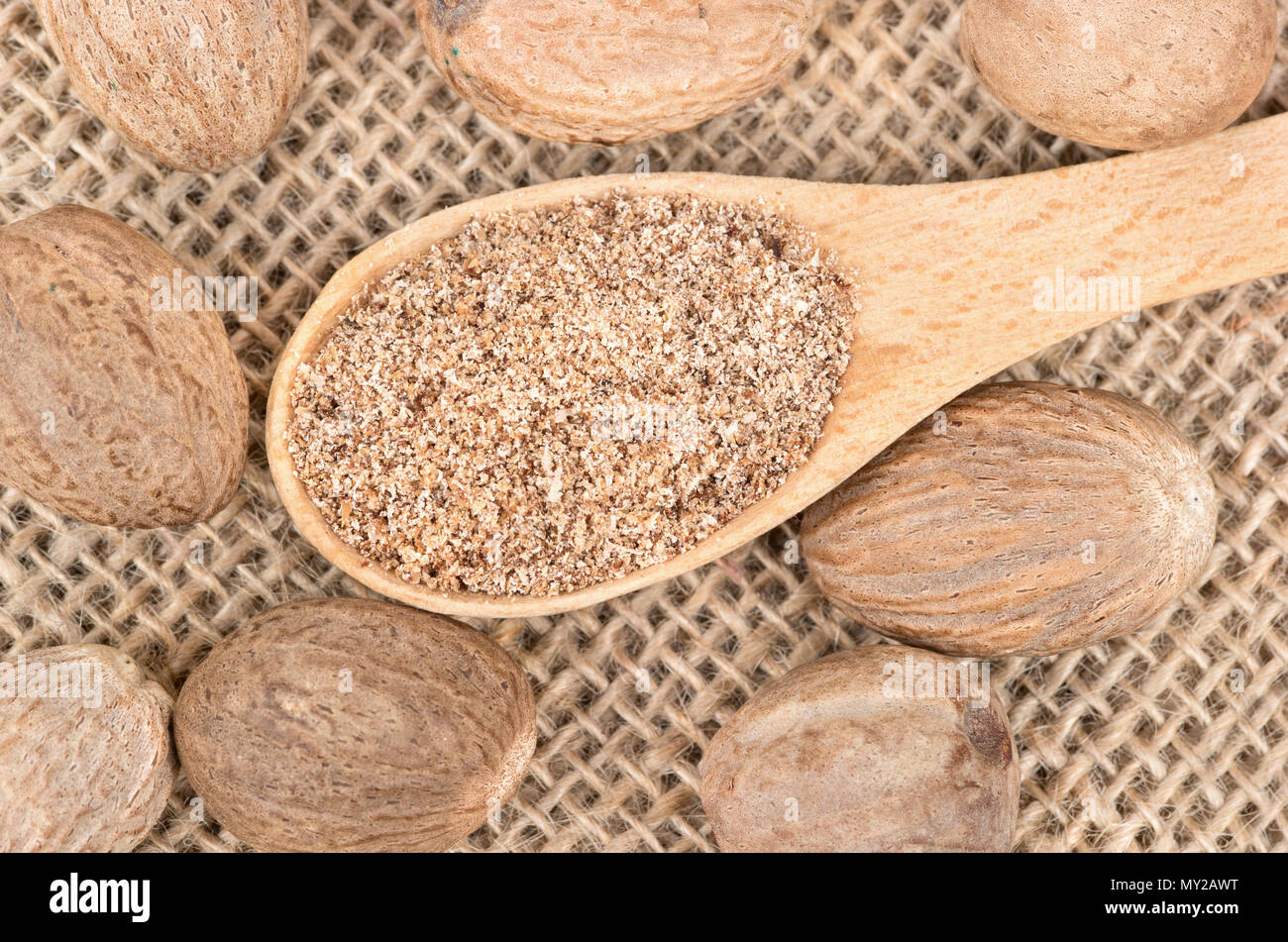Spice nutmeg in the spoon with scattered nuts on burlap, top view Stock ...