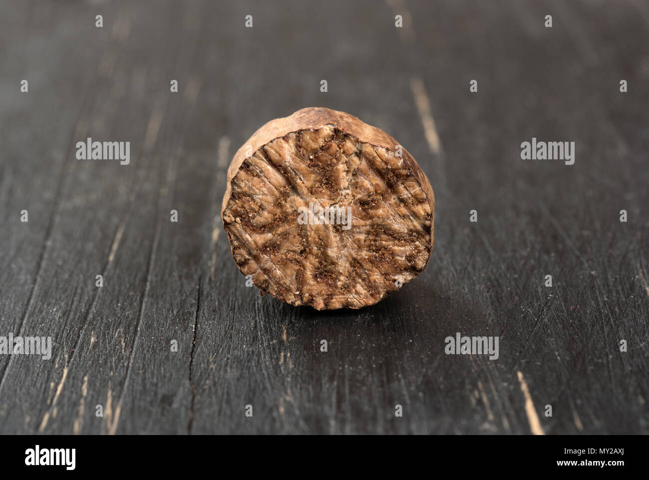 Half dry nutmeg on dark table closeup Stock Photo - Alamy