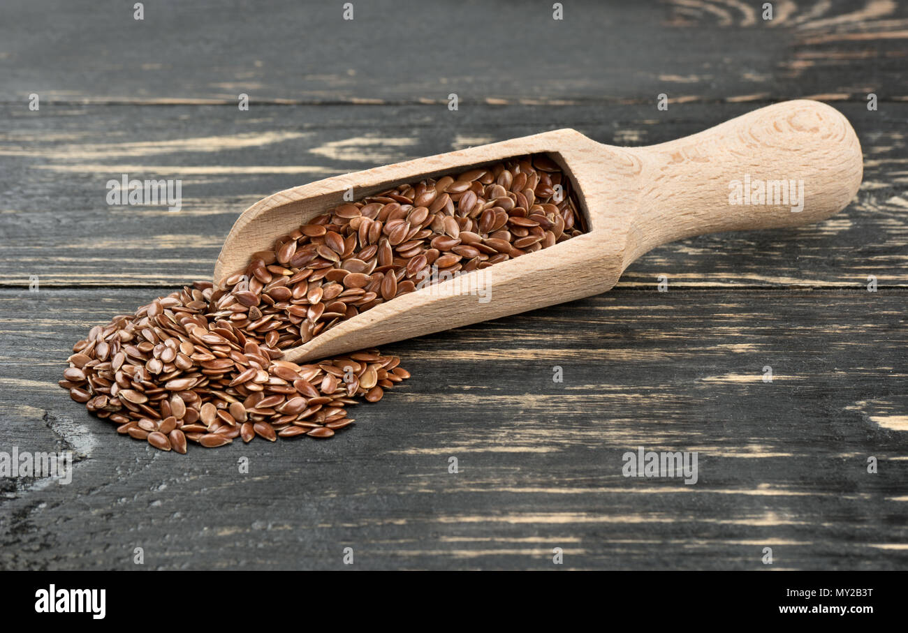 Raw flax seeds in the scoop on wooden background Stock Photo - Alamy