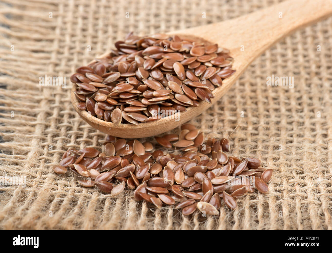 Flax seeds in the spoon and scattered beans on sackcloth Stock Photo ...
