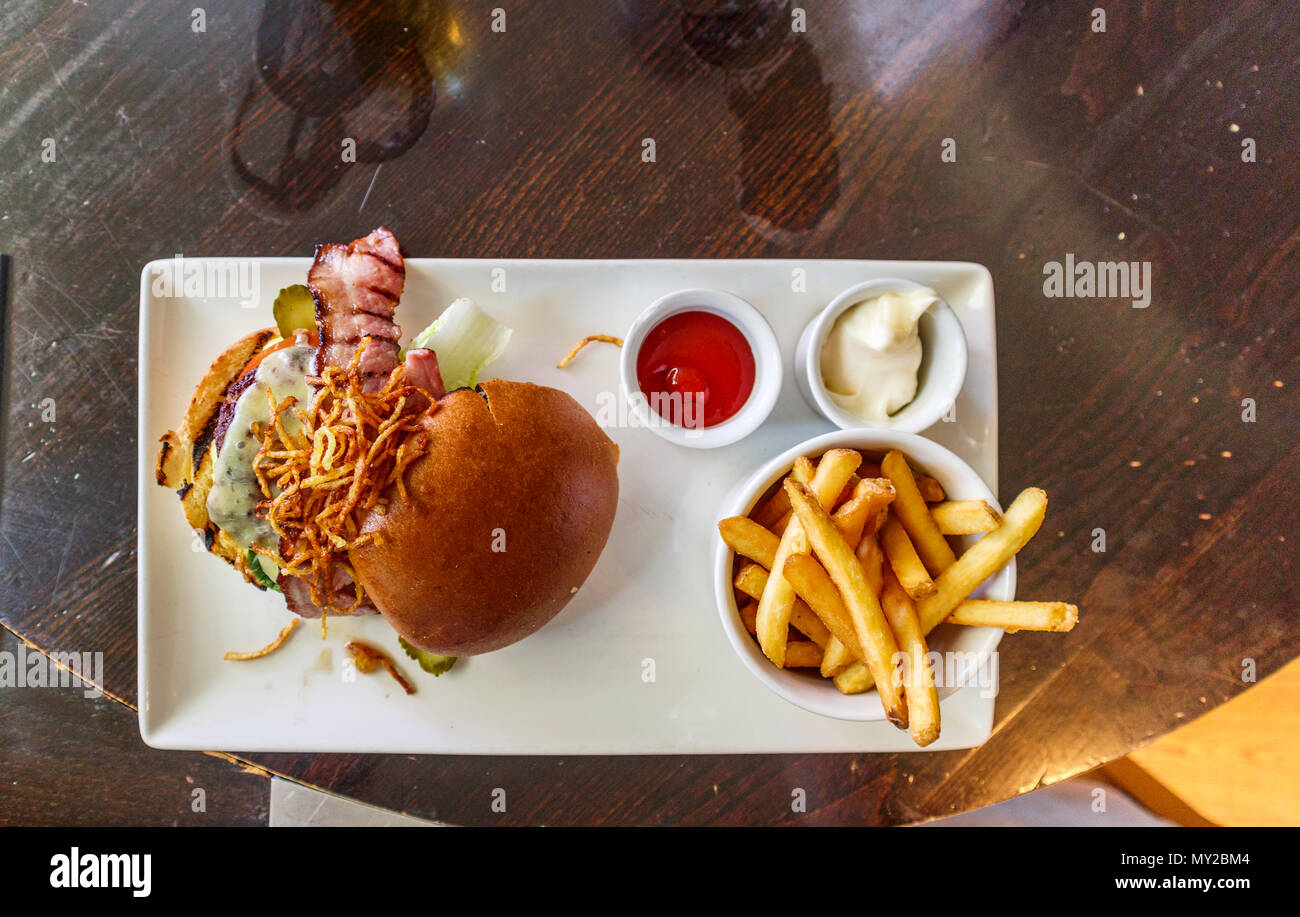 Typical British pub food: Cheeseburger in a bun with bacon and French ...