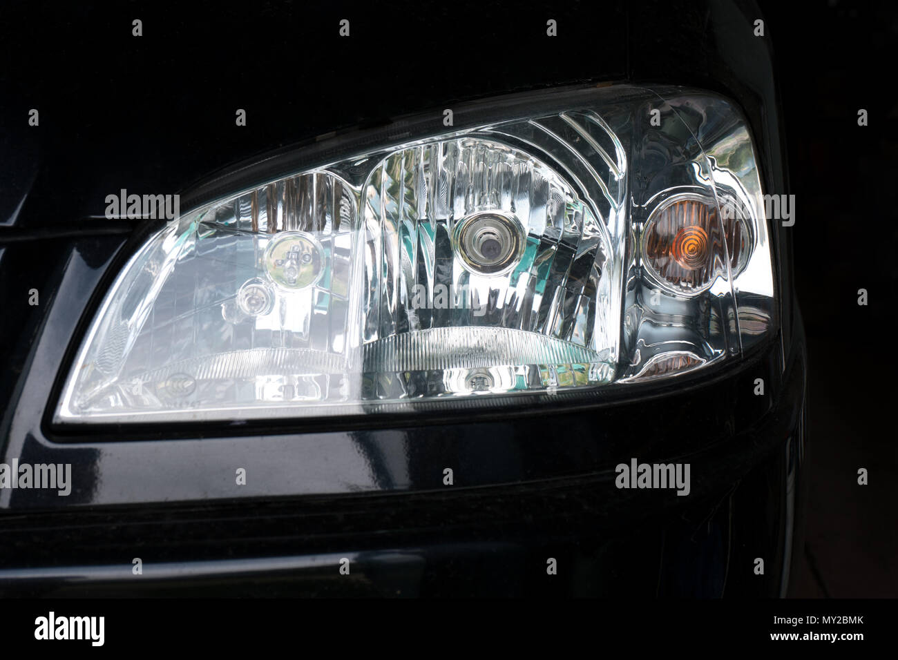 Headlight is off a black car close up Stock Photo - Alamy