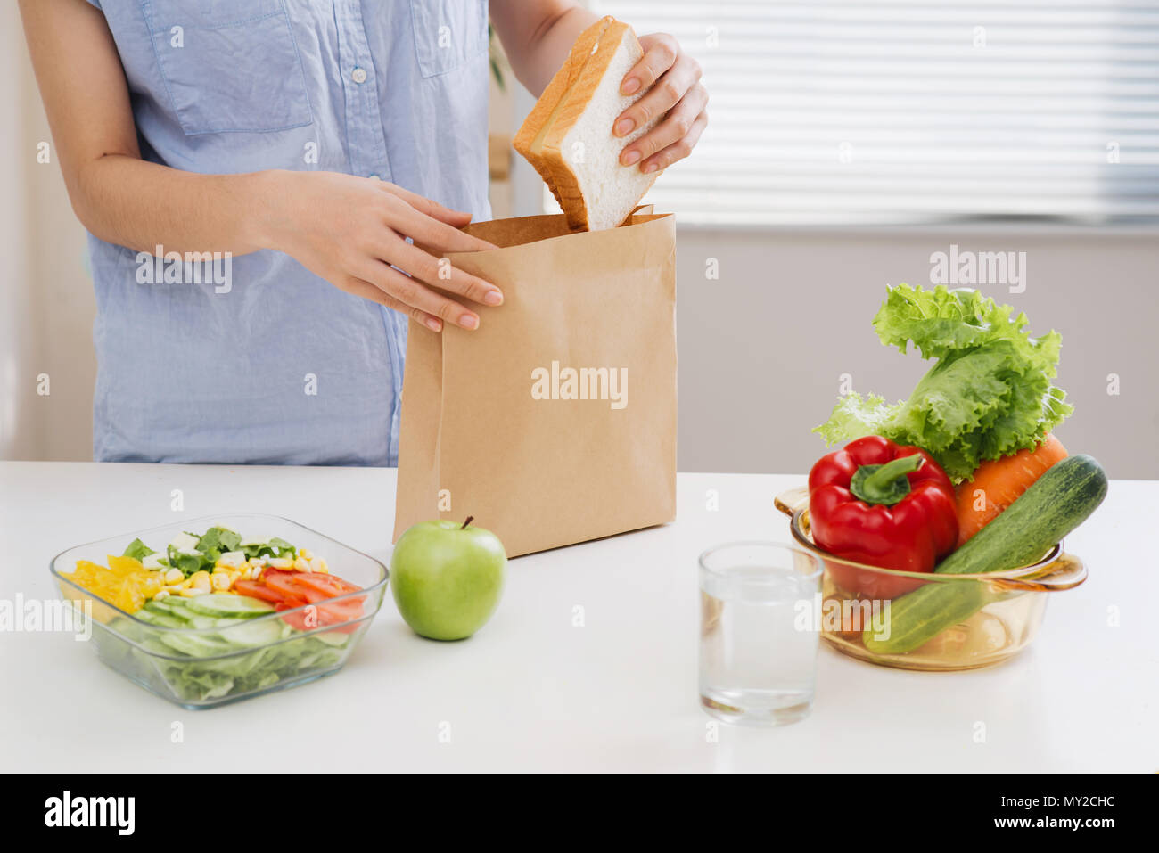 Mother preparing sandwich for school lunch on table Stock Photo - Alamy