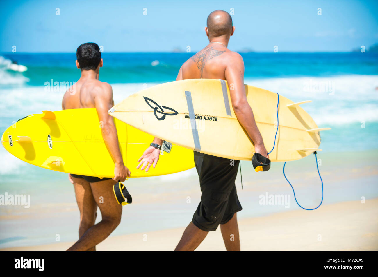 RIO DE JANEIRO - FEBRUARY 9, 2017: Surfer with tribal tattoo walks with ...