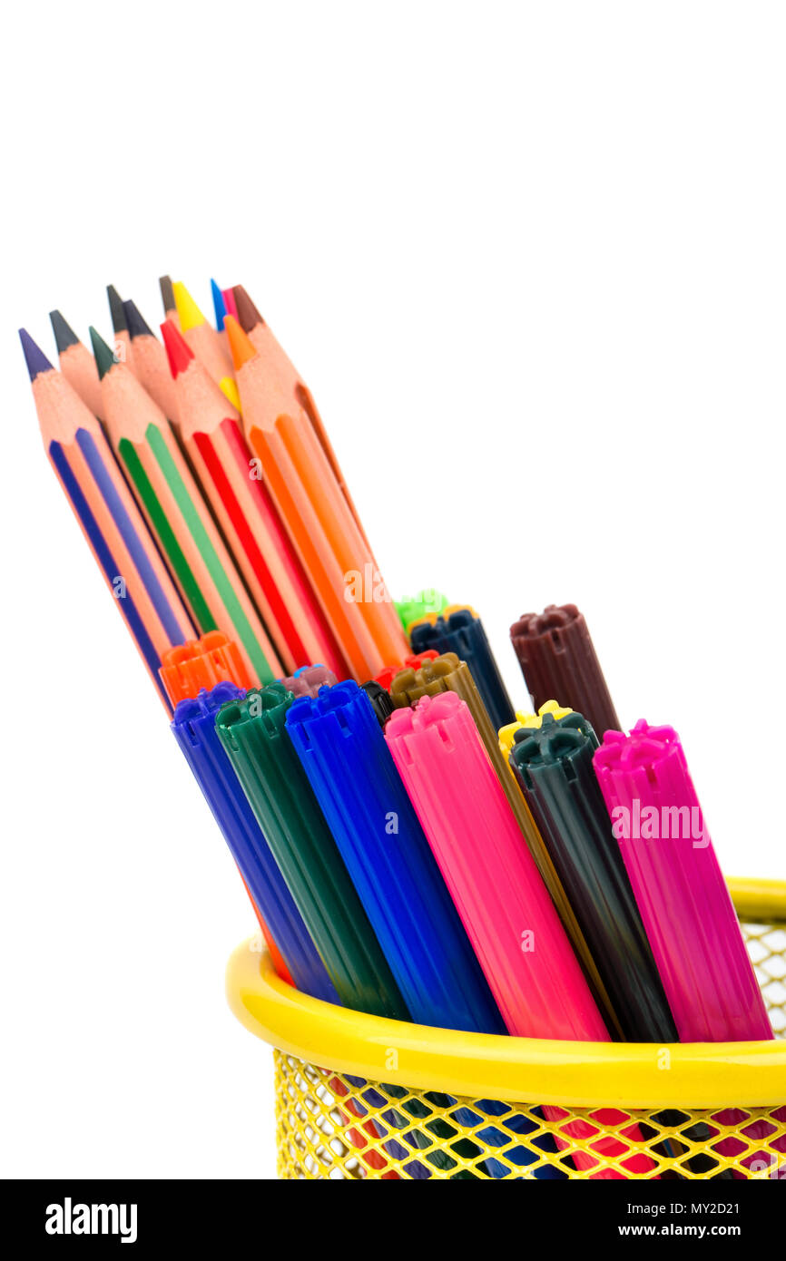 Colored pencils and markers in a basket closeup on white background ...