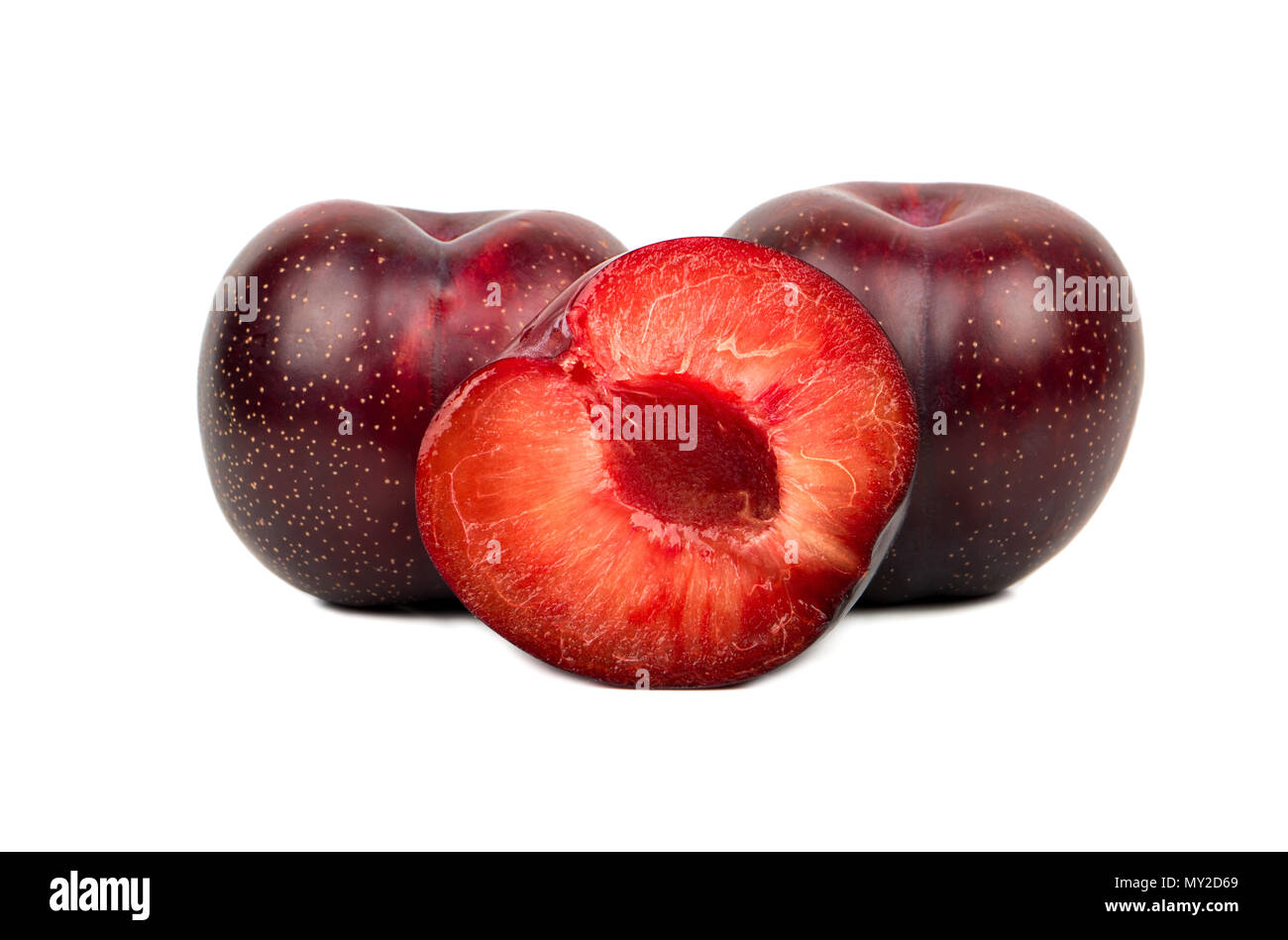 Big red plum with juicy half on white background Stock Photo - Alamy
