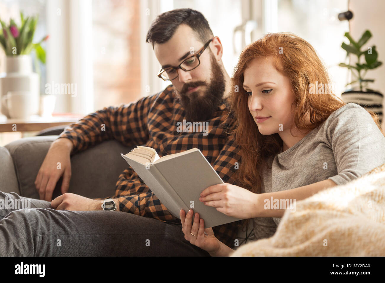Woman and man reading a book. Lovely couple at home concept Stock Photo ...
