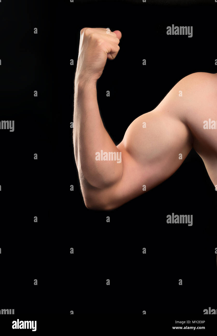 Beginner bodybuilder demonstrates his biceps on black background Stock ...