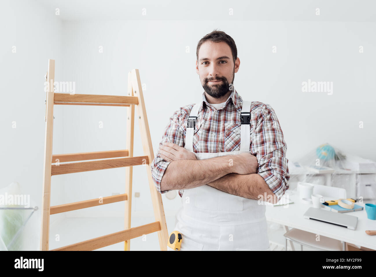 Confident professional painter posing with arms crossed, home ...