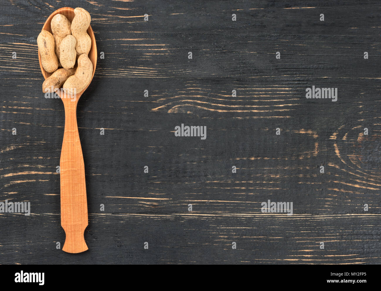 Dry peanuts in a shell in a spoon on an empty wooden background Stock ...
