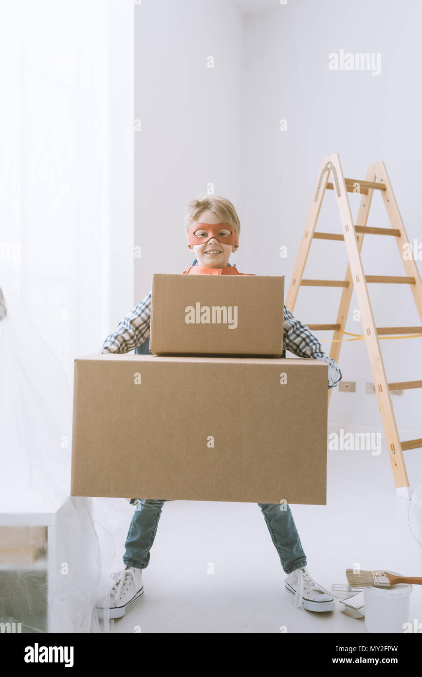 Cute superhero boy with mask and cape, he is carrying easily heavy ...