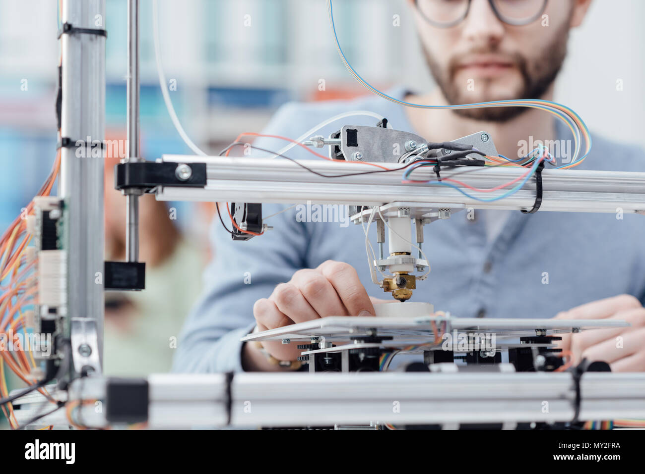 Engineering student using a 3D printer in the lab and printing a ...