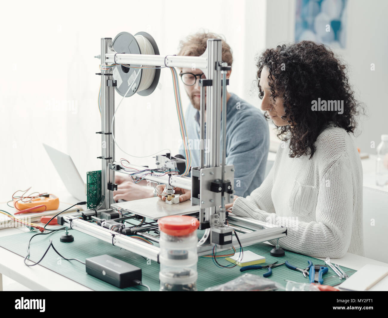 Engineering students using a 3D printer in the lab, they are using a ...