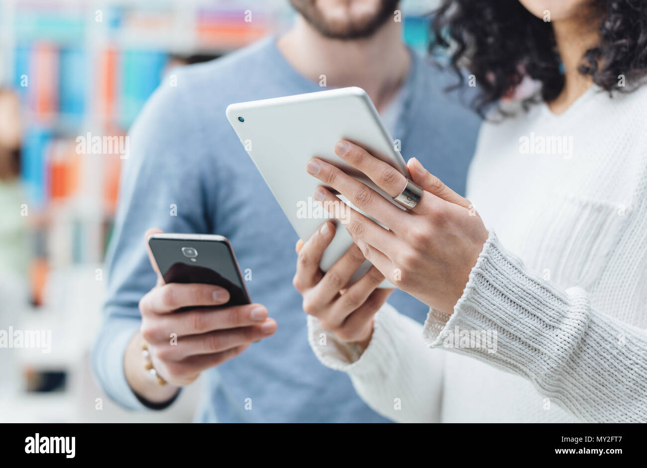 Friends sharing social media contents on mobile devices, they are ...