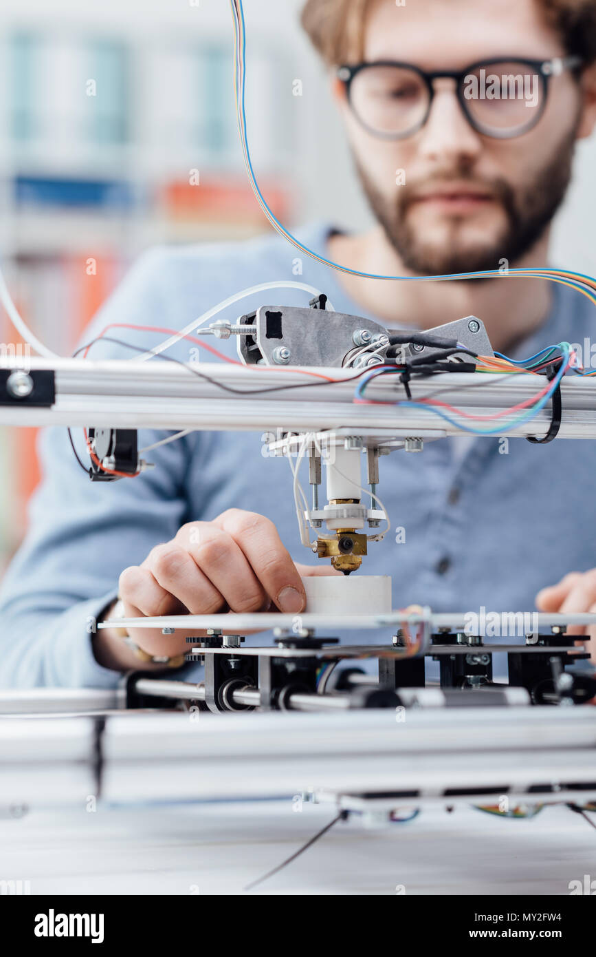 Engineering student using a 3D printer in the lab and printing a ...