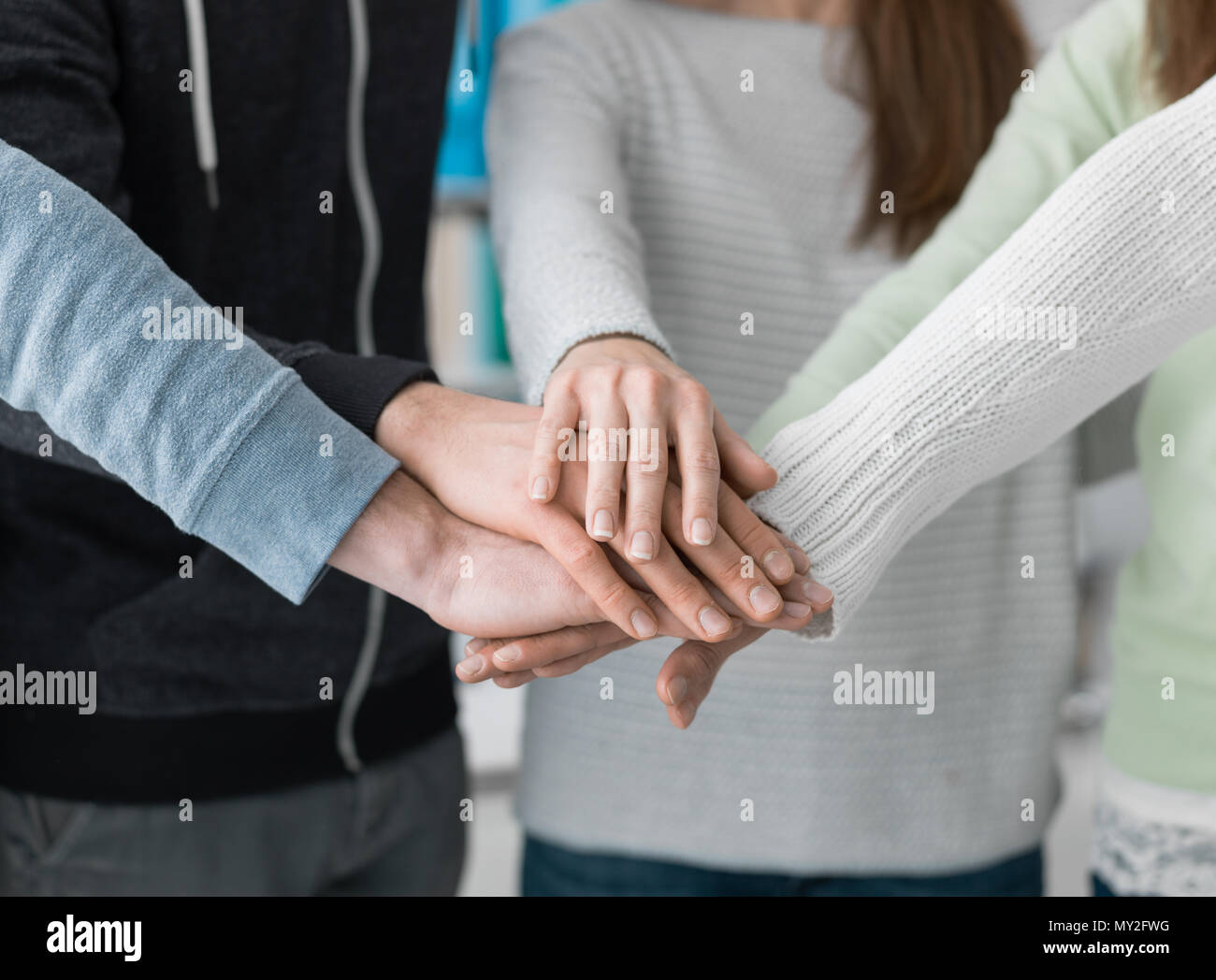 Young people stacking hands together: teamwork, collaboration and ...