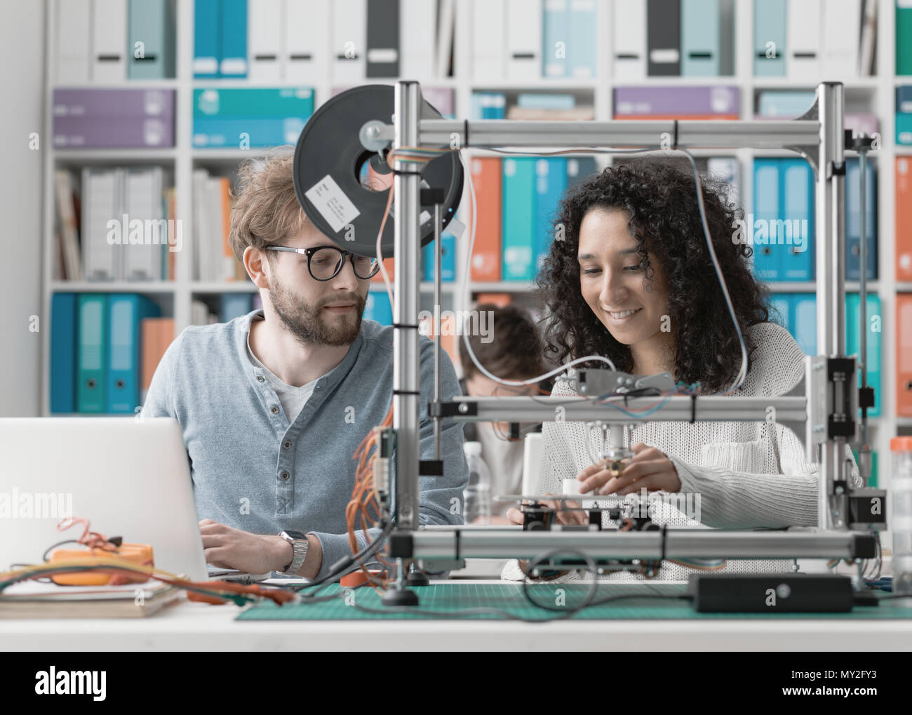 Engineering students using a 3D printer in the laboratory, they are ...