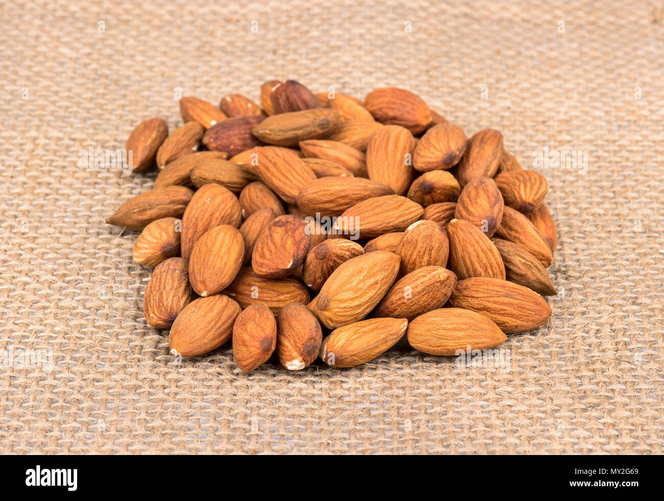 Pile of dry almonds on sacking Stock Photo - Alamy