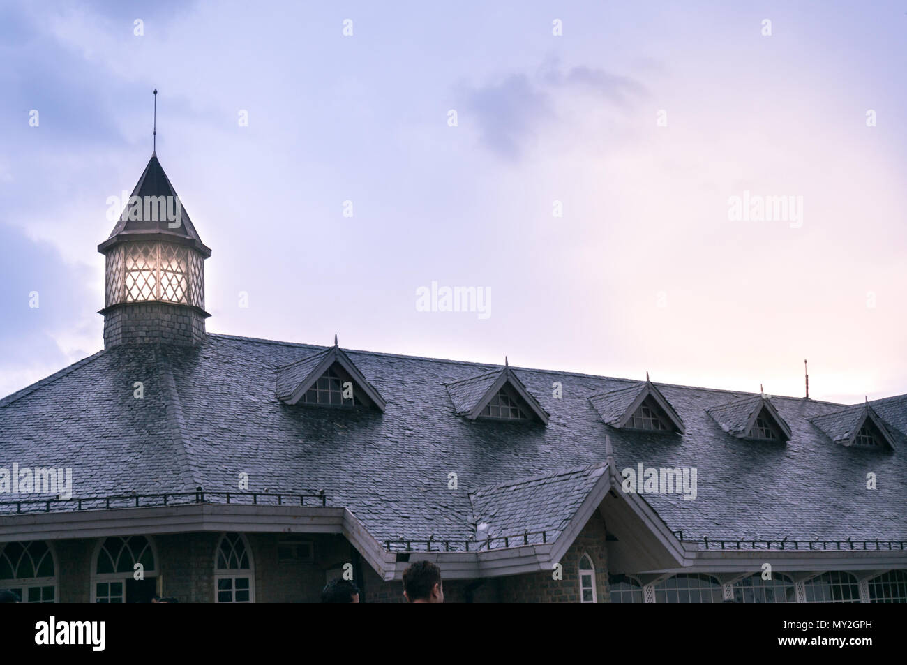 building with a sloping roof, windows and a tower shot against the ...