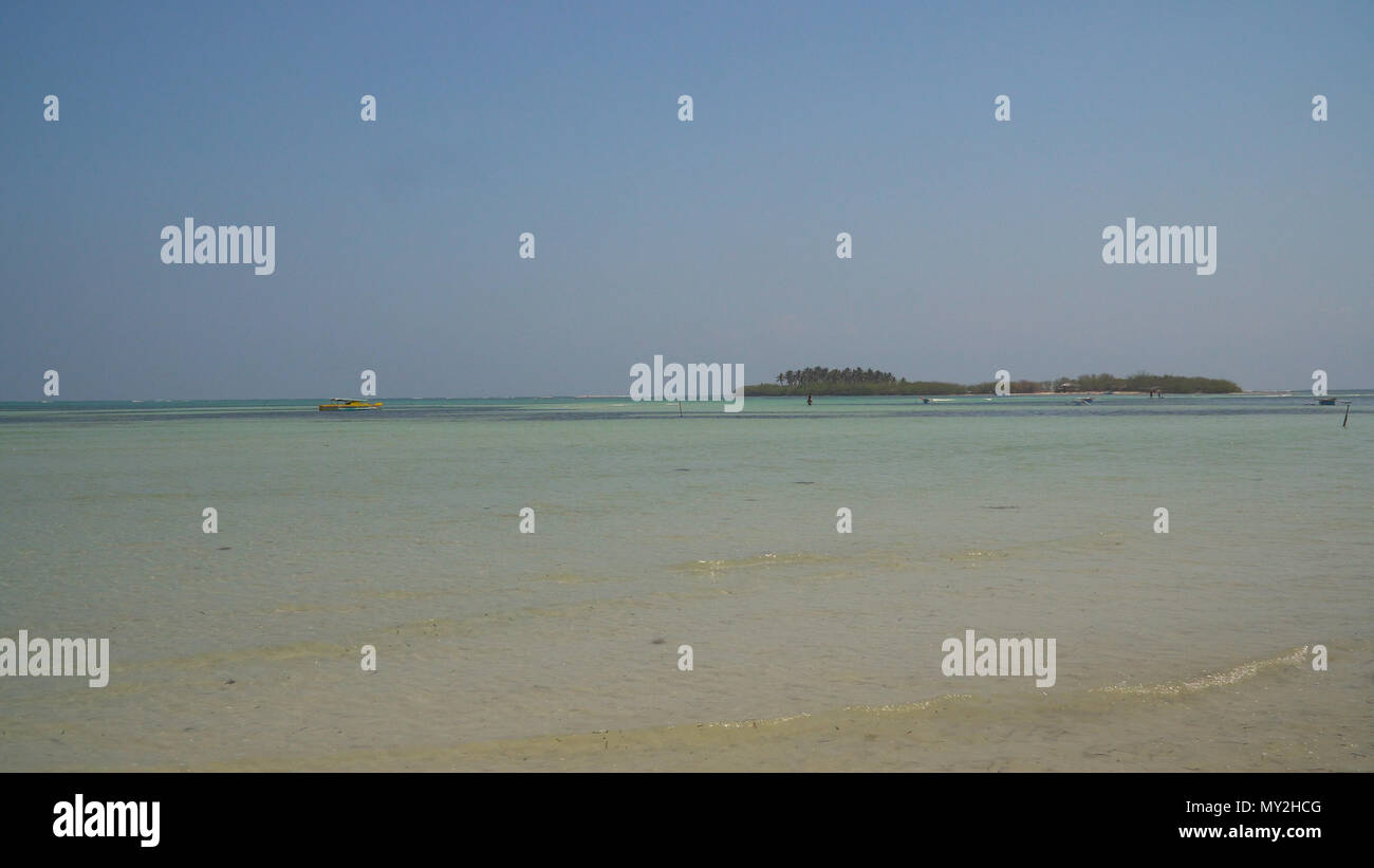 Tropical island with white sandy beach, palm trees in blue lagoon ...