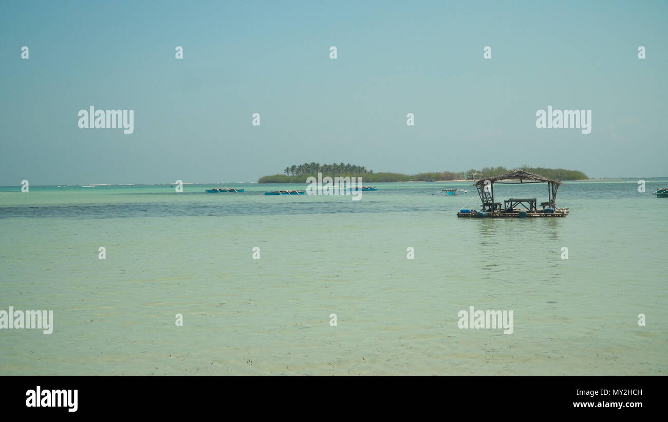 Tropical island with white sandy beach, palm trees in blue lagoon ...
