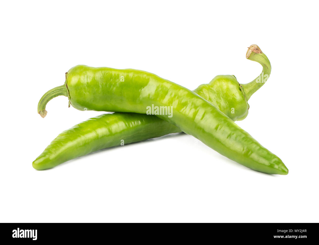 Two of sharp green peppers stacked on a cross on a white background ...