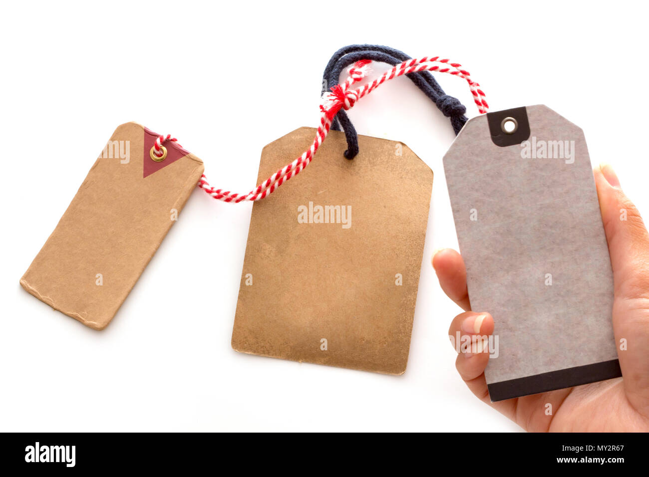 Closeup of hands holding old brown paper tag or label, cardboard price ...
