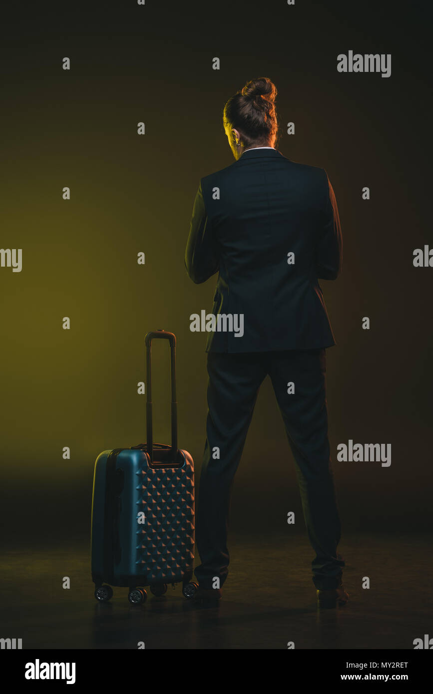 back view of young man in suit standing near suitcase Stock Photo - Alamy