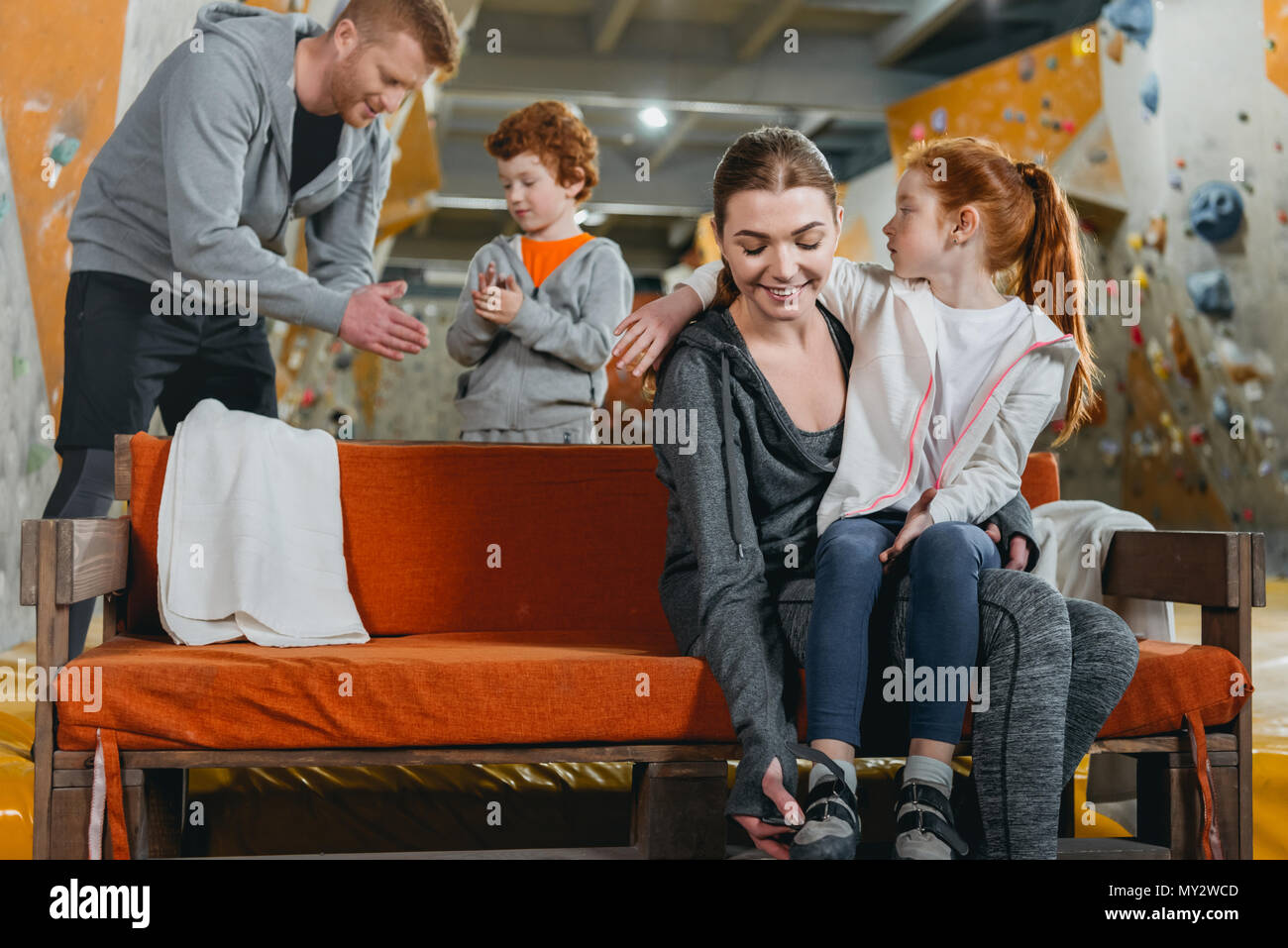A family with kids at gym, changing clothes and preparing to climb a ...