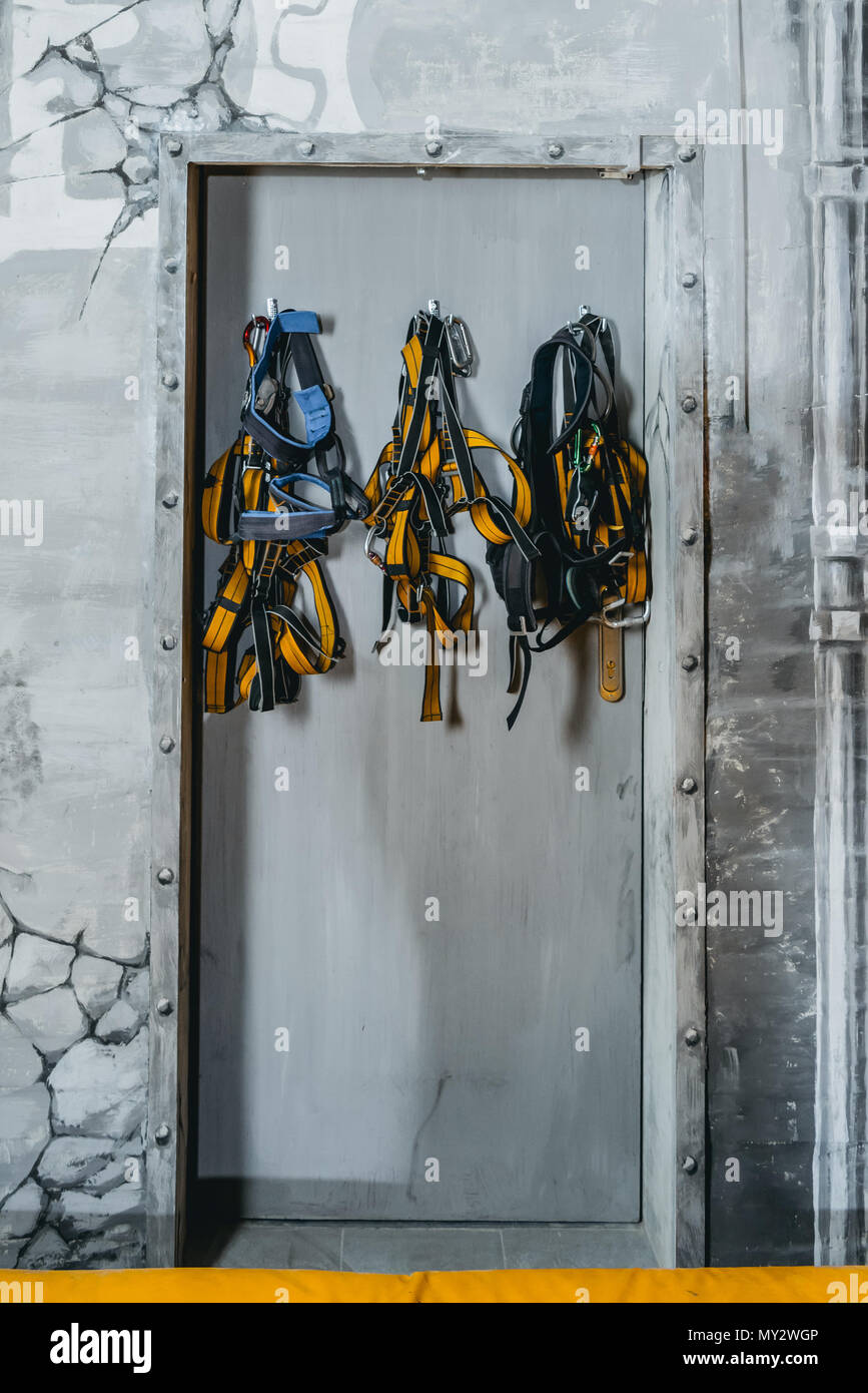 Climbing harnesses hanging on the wall at the gym Stock Photo - Alamy