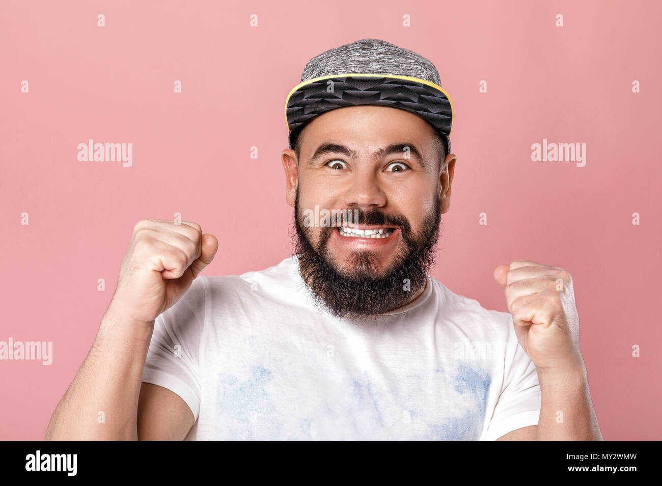 Young happy bearded football fan in cap celebrating. emotional man ...
