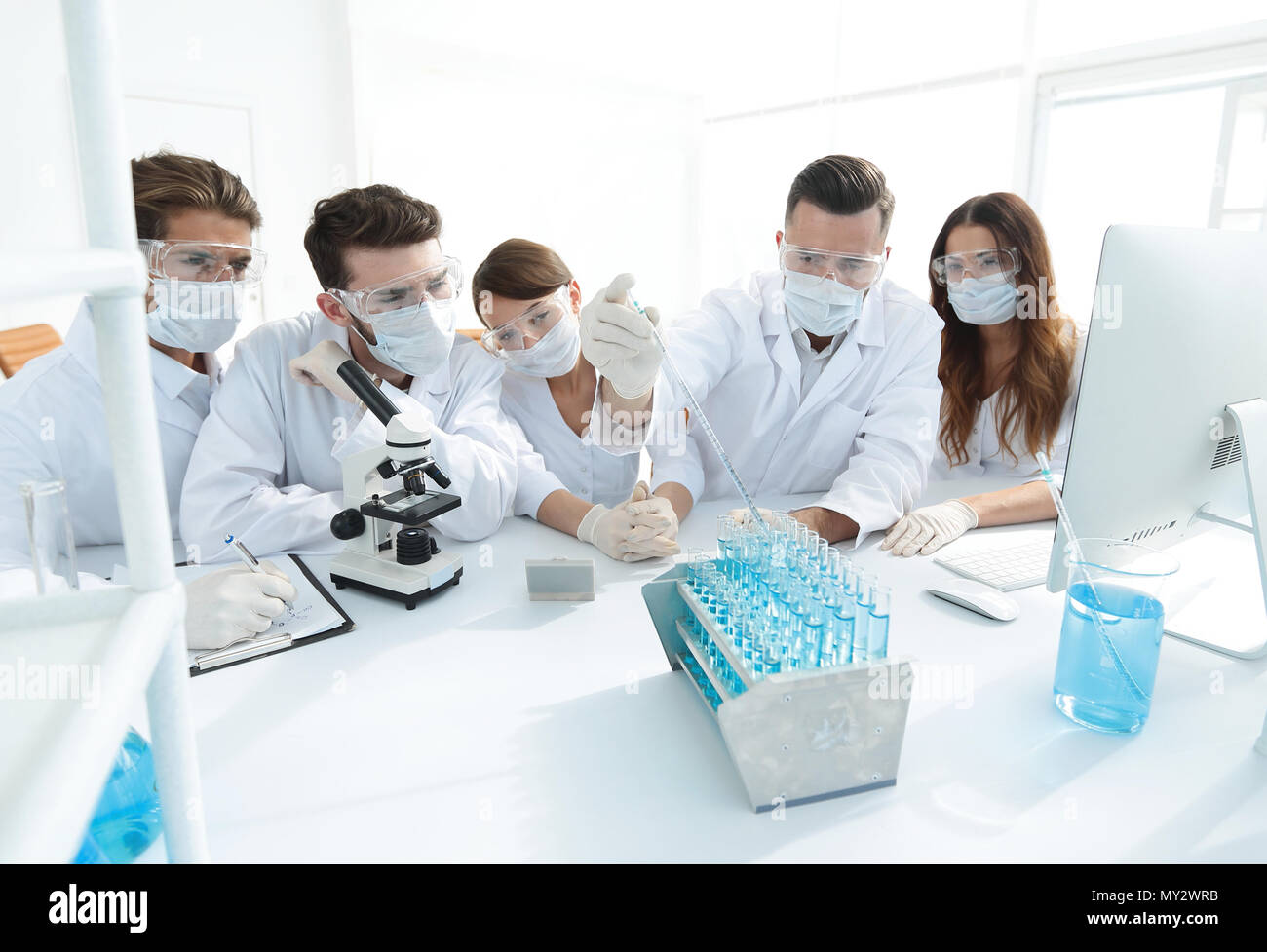 medical doctors are working with test tubes and microscope at the lab ...