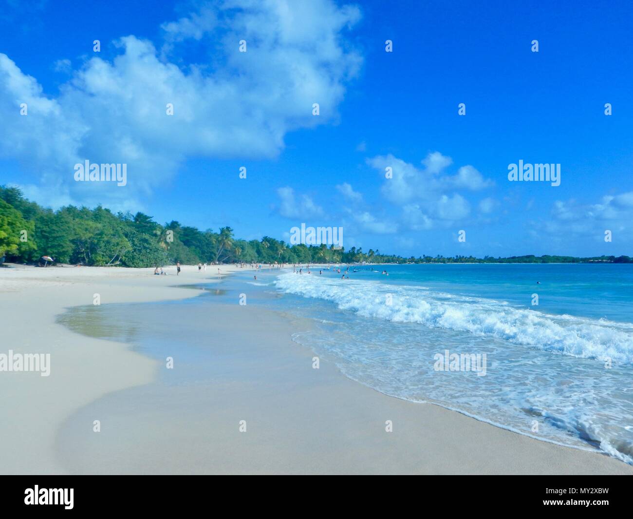 Beautiful beach day with tourists taking a stroll in the sand, the ...
