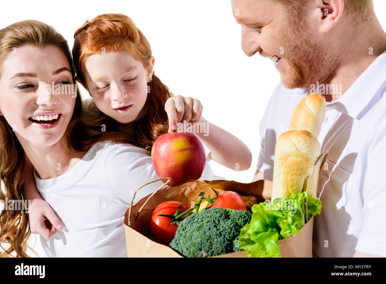 happy young family with one child holding grocery bag full of food ...