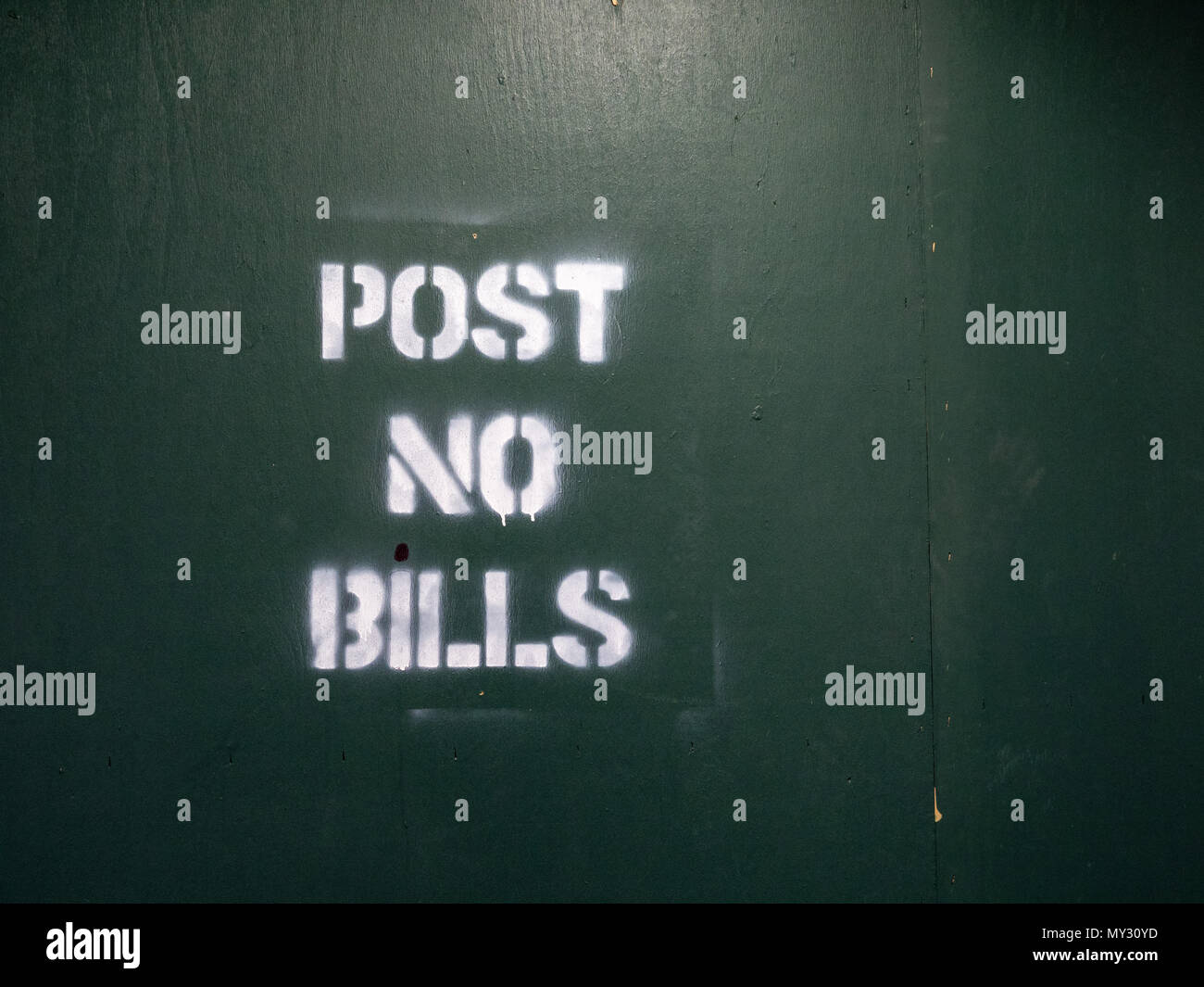 A post no bills spray painted warning sign at a city construction area ...